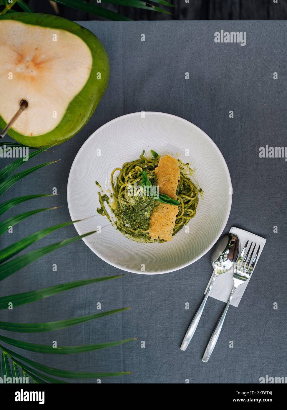 Spaghetti with pesto and coconut under palm tree Stock Photo - Alamy
