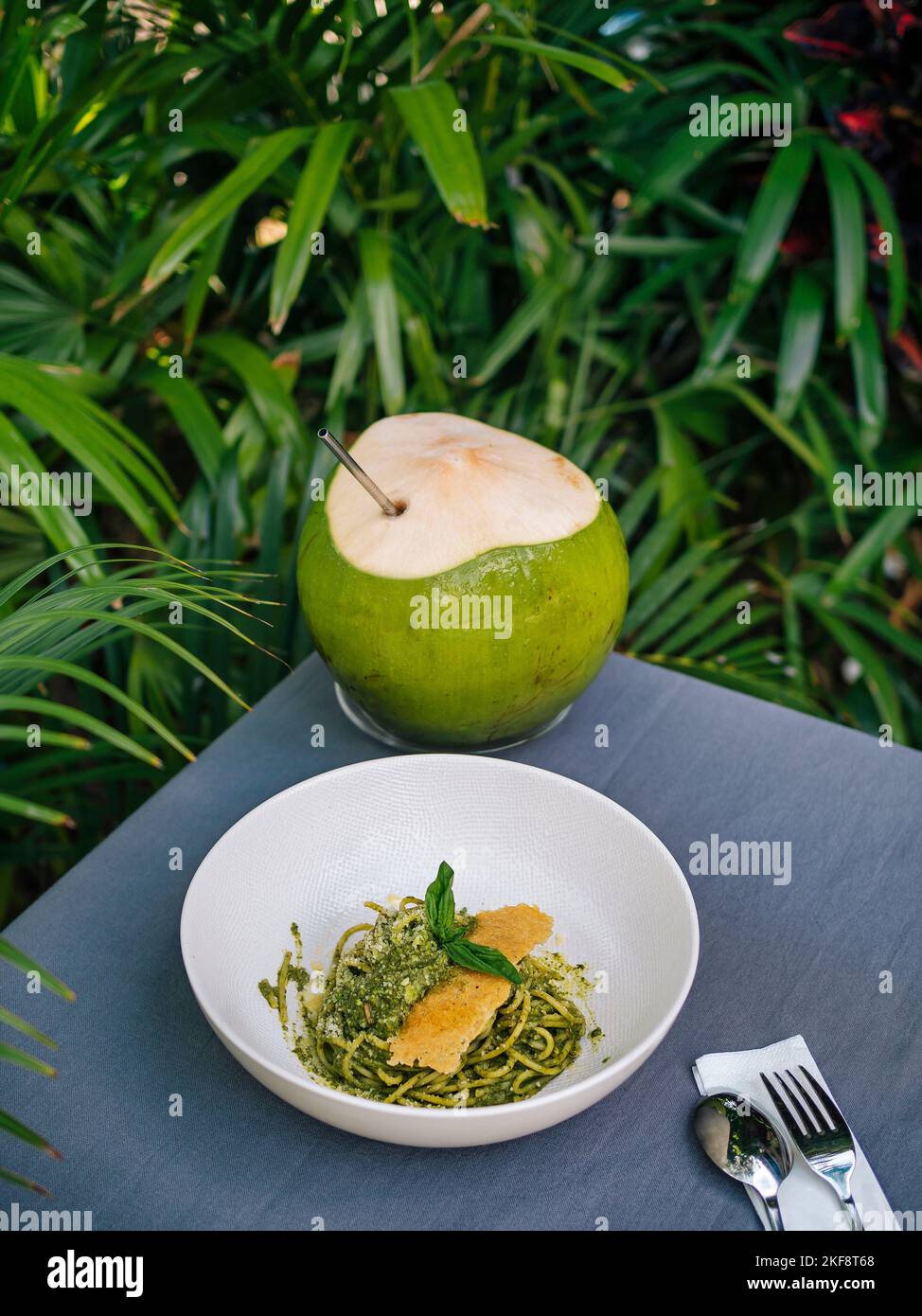 Spaghetti with pesto and coconut under palm tree Stock Photo - Alamy