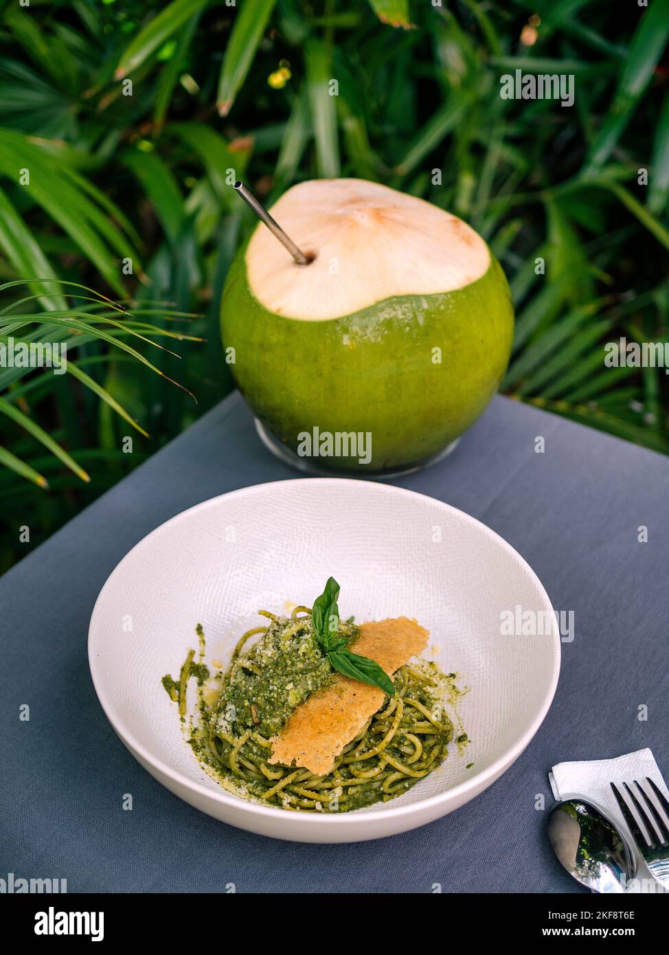 Spaghetti with pesto and coconut under palm tree Stock Photo - Alamy