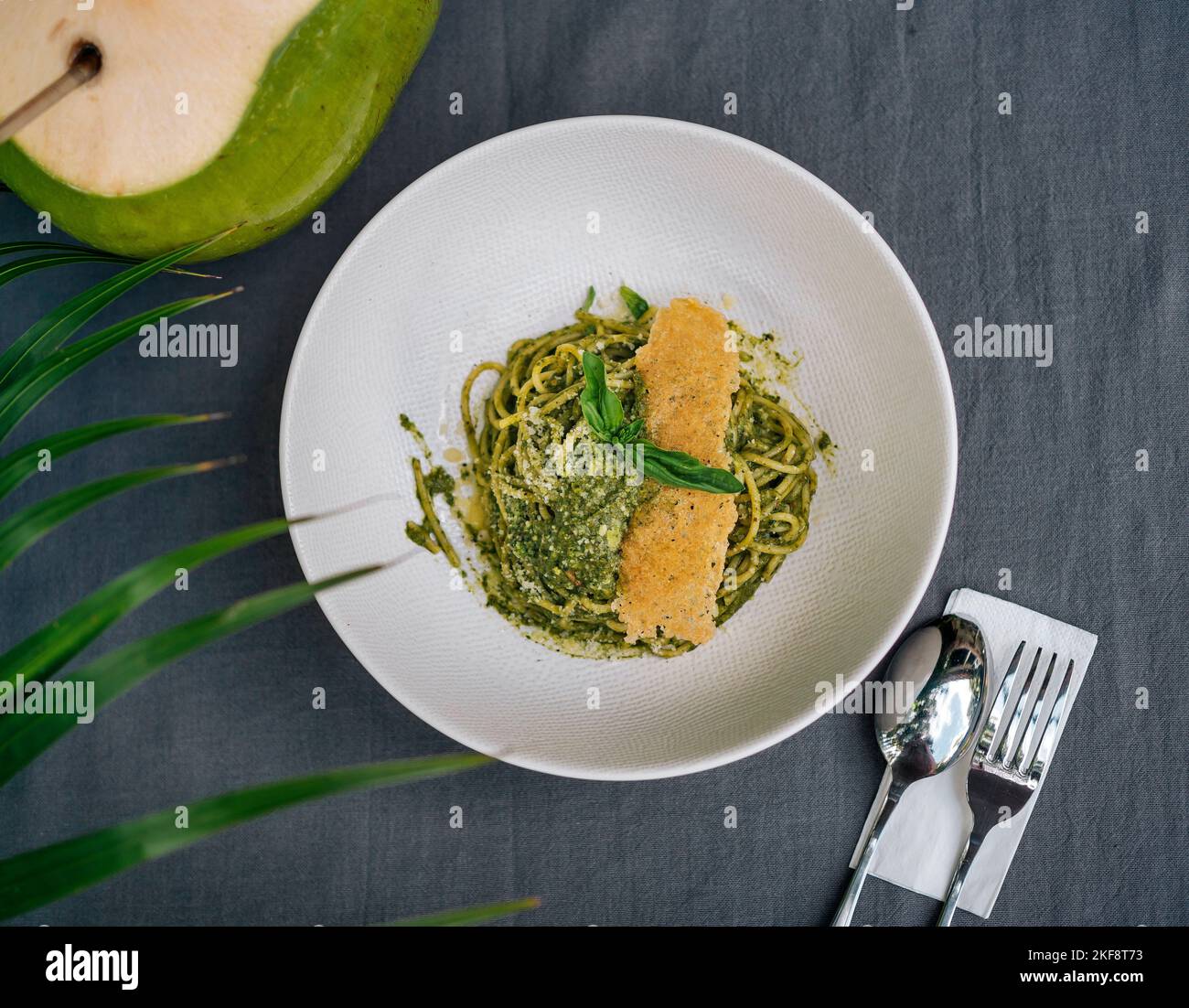 Spaghetti with pesto and coconut under palm tree Stock Photo - Alamy