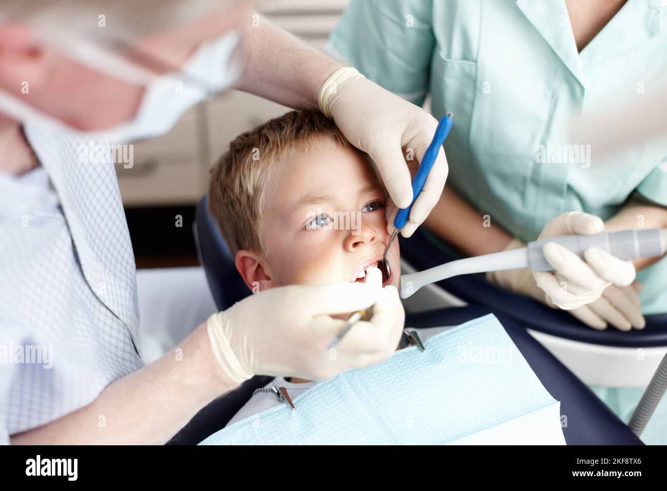Dental hygiene. Portrait of dentist cleaning teeth of young patient for ...