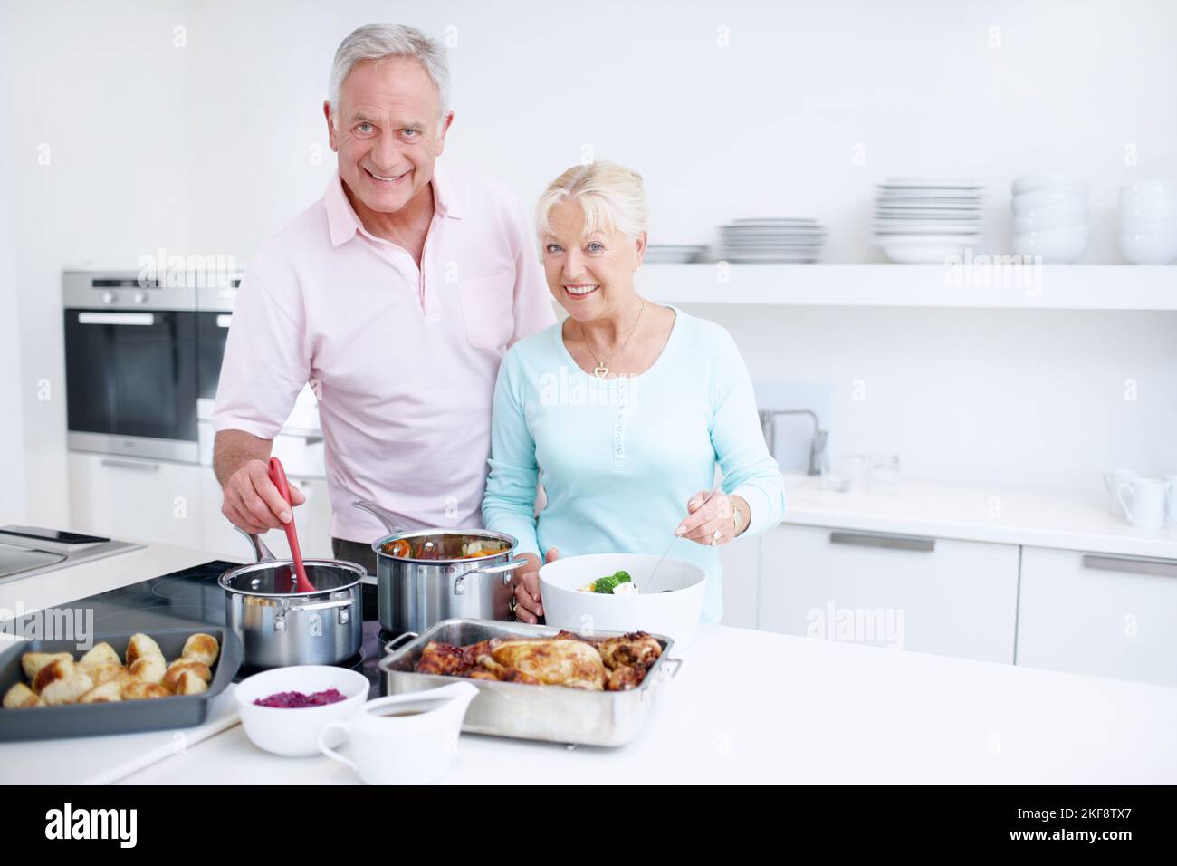 Cooking a sunday roast for the family. A senior couple cooking together ...
