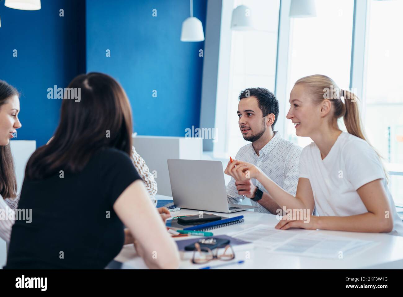 Students gather around table and talk while studying Stock Photo - Alamy