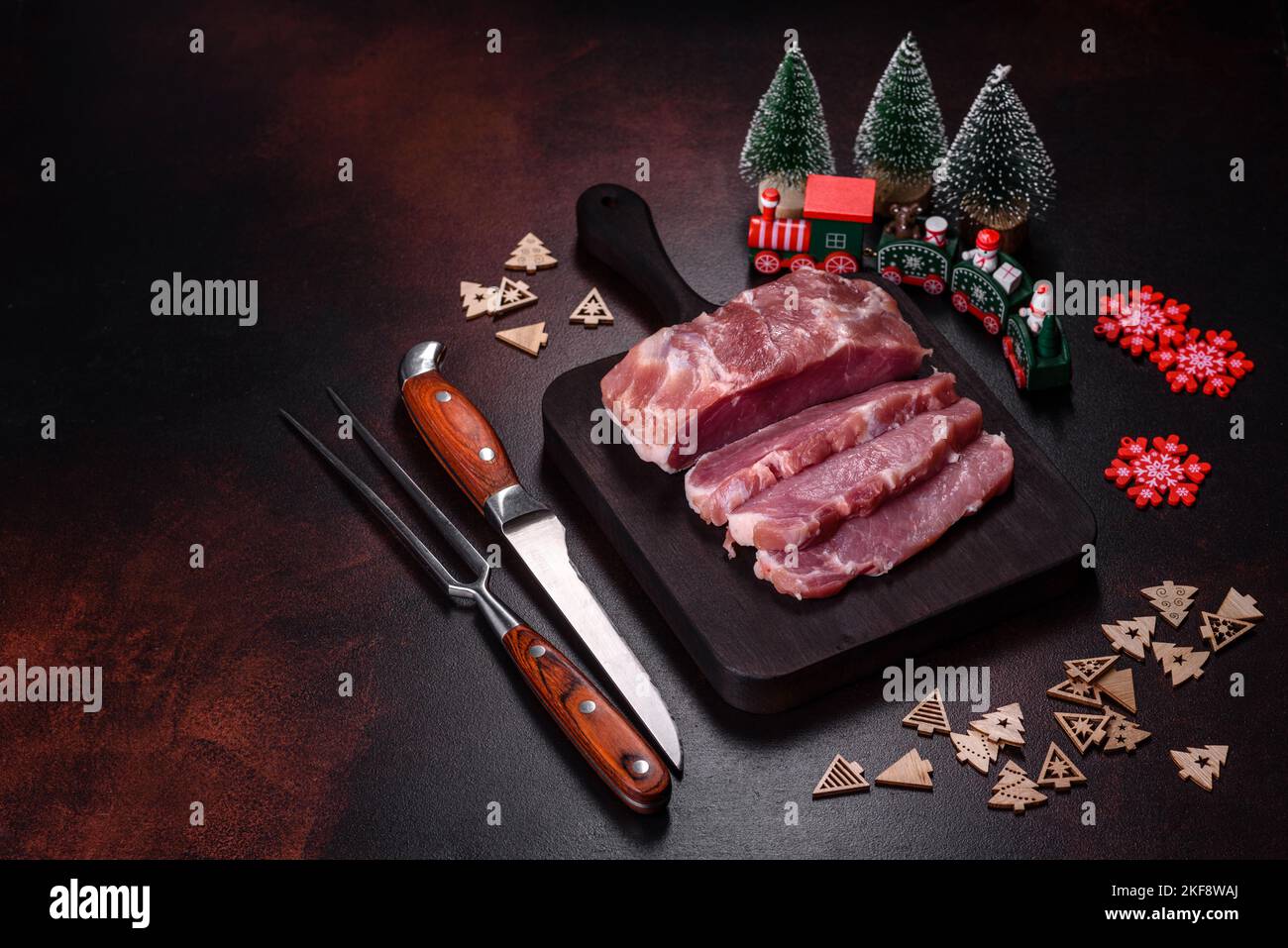 Fresh piece of raw pork with spices, salt and herbs on a wooden cutting ...