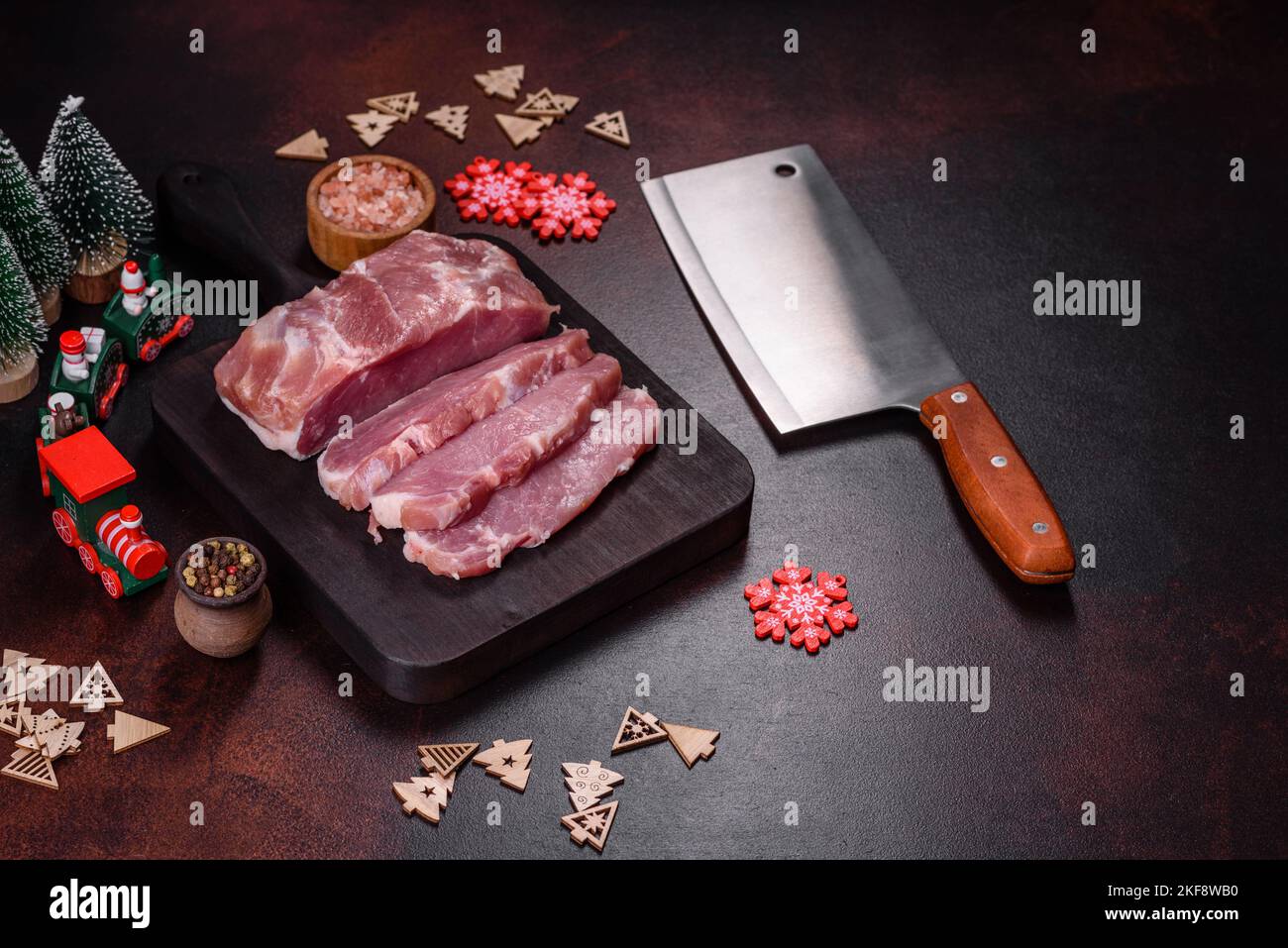 Fresh piece of raw pork with spices, salt and herbs on a wooden cutting ...