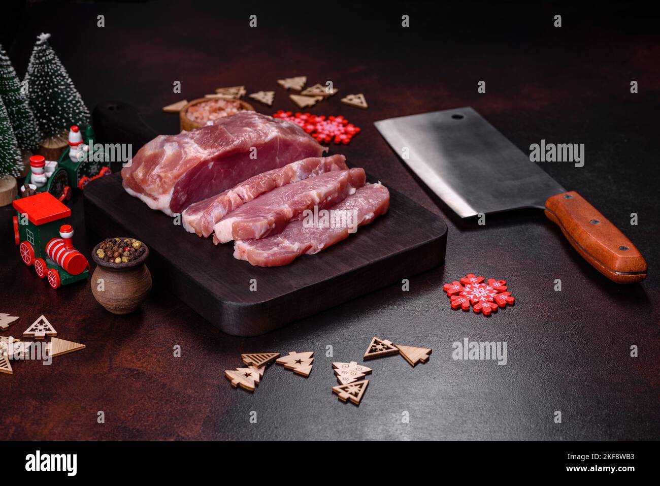 Fresh piece of raw pork with spices, salt and herbs on a wooden cutting ...