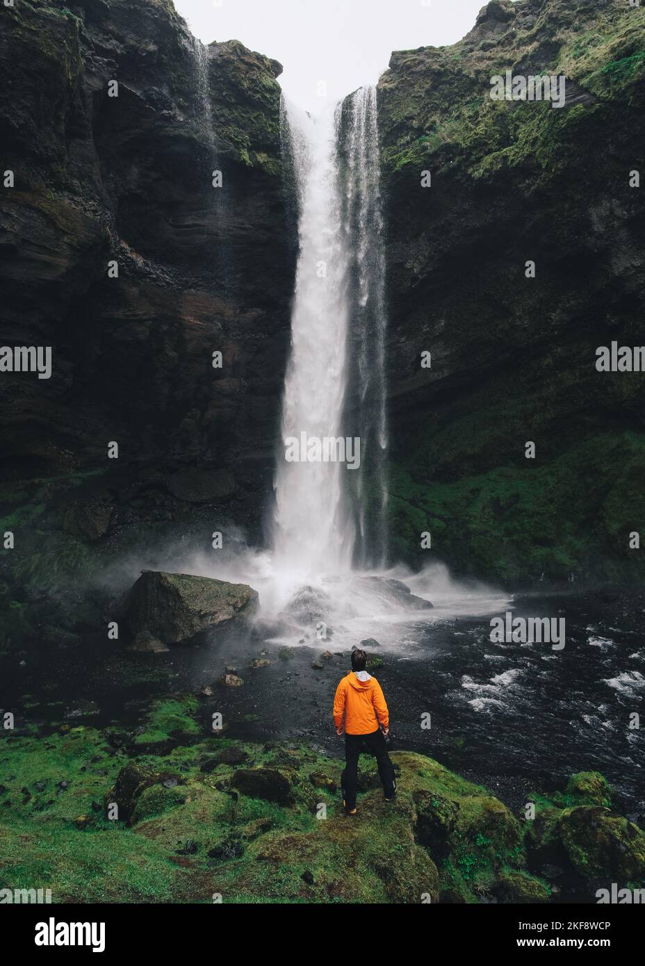 A male hiker looking at the beautiful Kvernufoss waterfall in Iceland ...