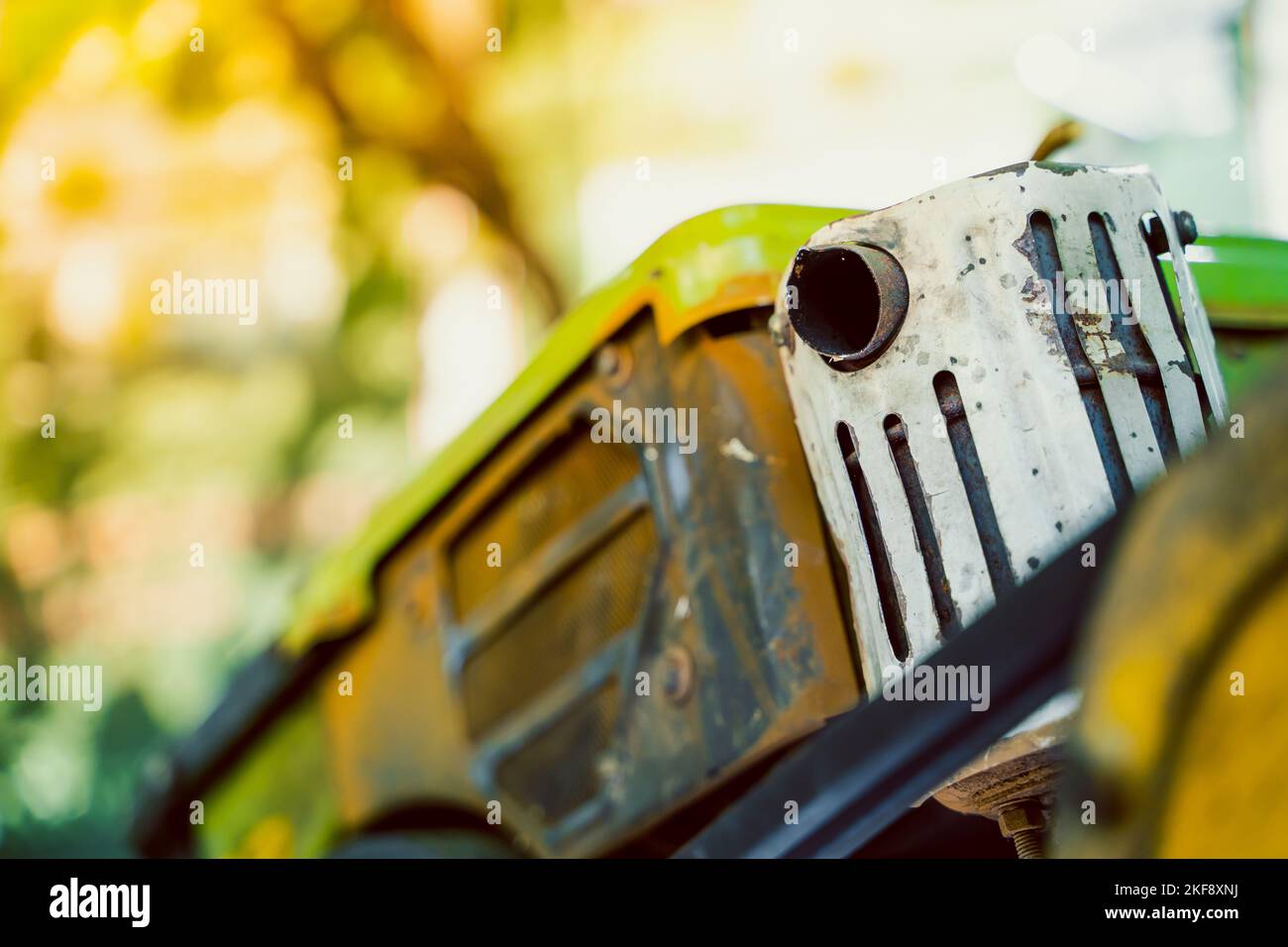 The muffler of the exhaust pipe of a walk-behind tractor against the ...