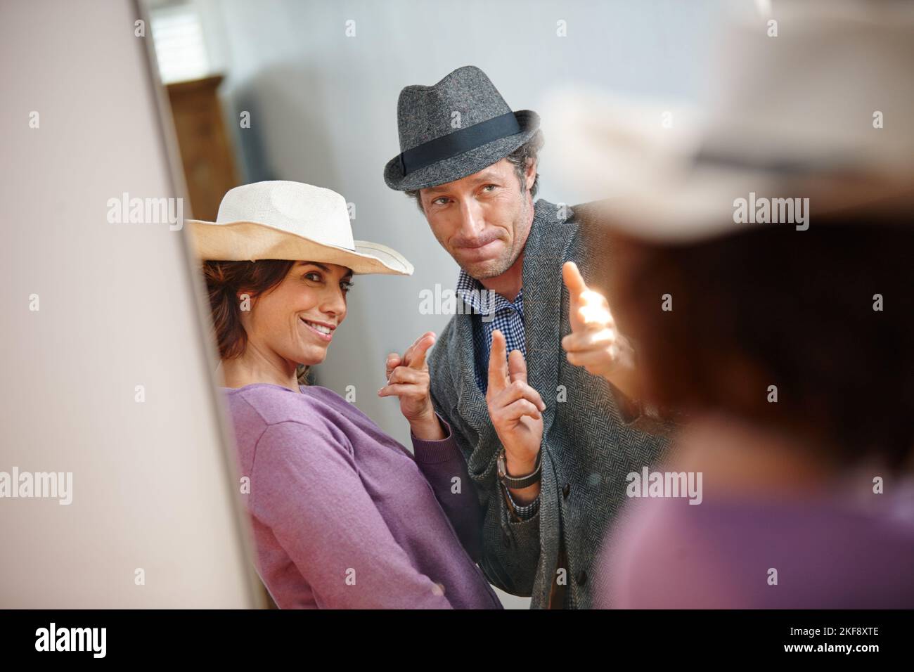 Getting their groove back. a playful couple looking in the mirror Stock ...