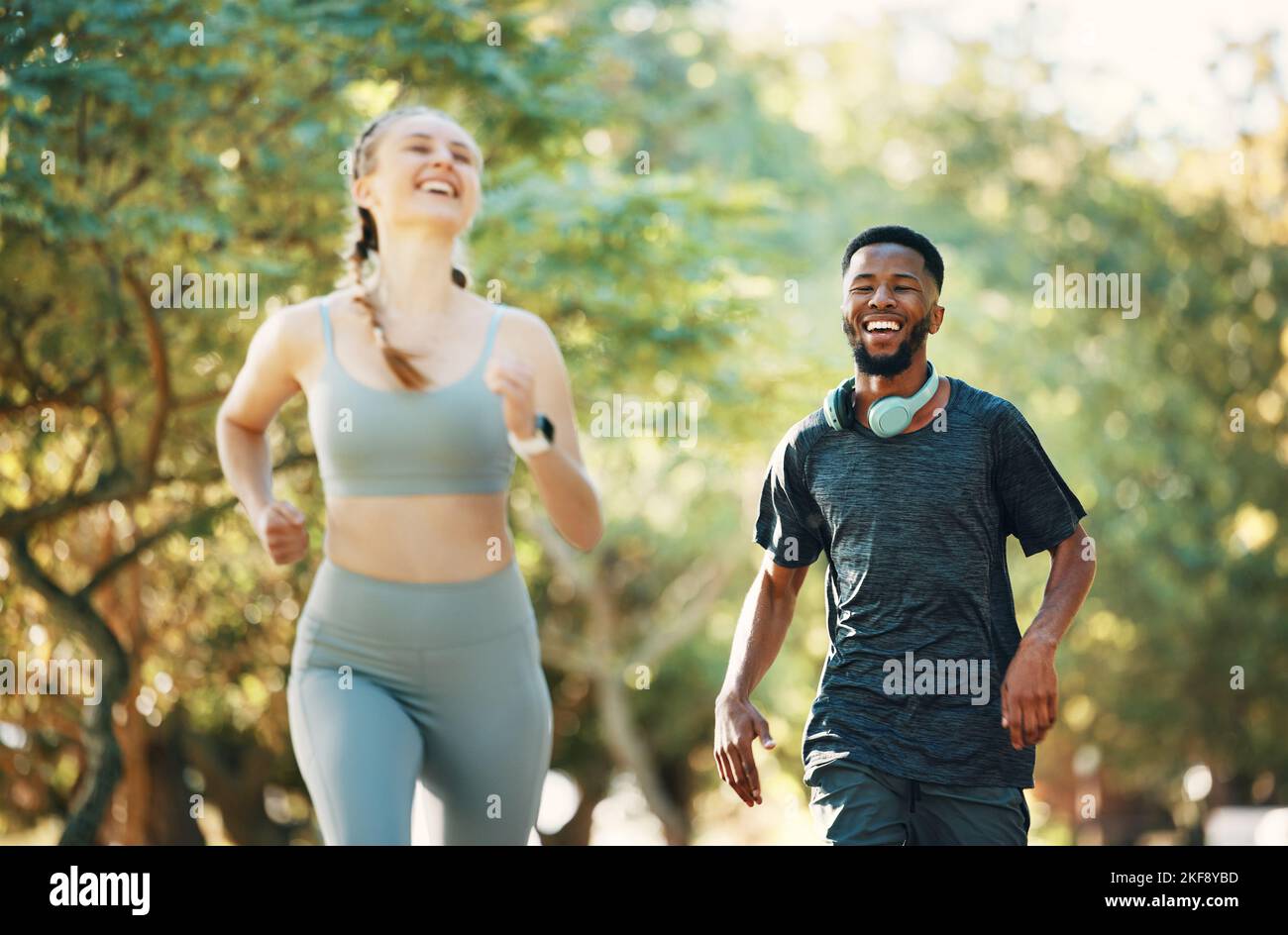 Running, fitness and fun with a diversity couple outdoor in the park ...