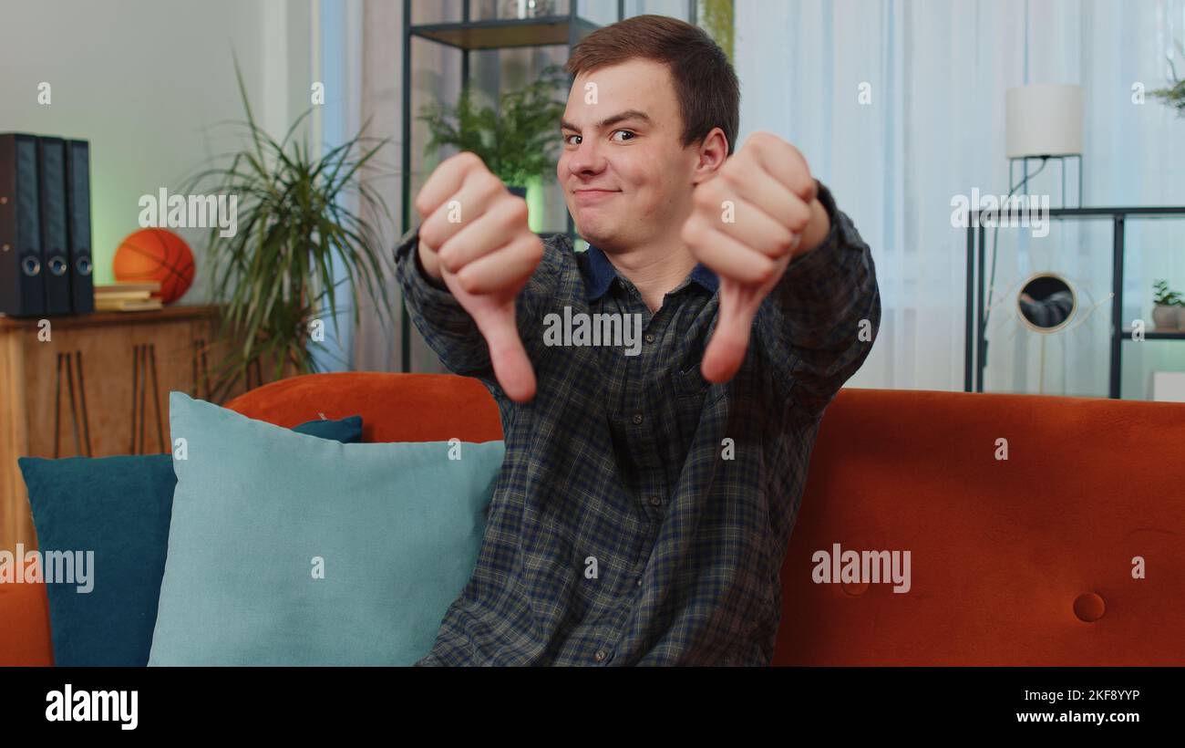 Dislike. Upset teen man showing thumbs down sign gesture, expressing ...