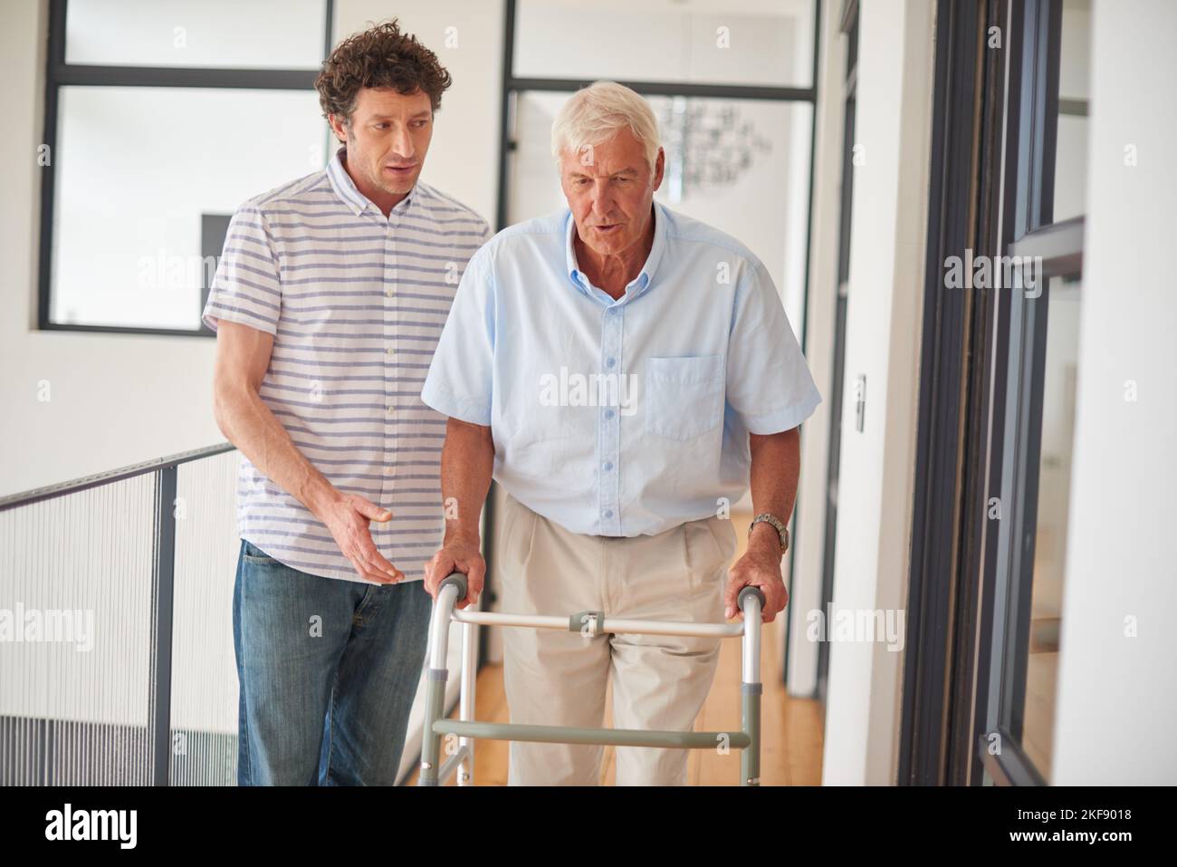 You can do it. a man assisting his elderly father with an orthopedic ...