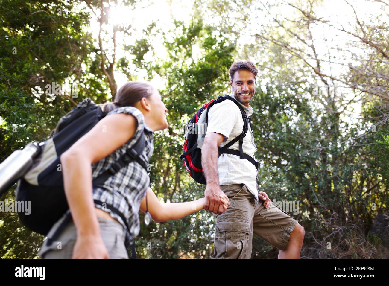 I know the way...Handsome hiker looking down at his girlfriend while ...