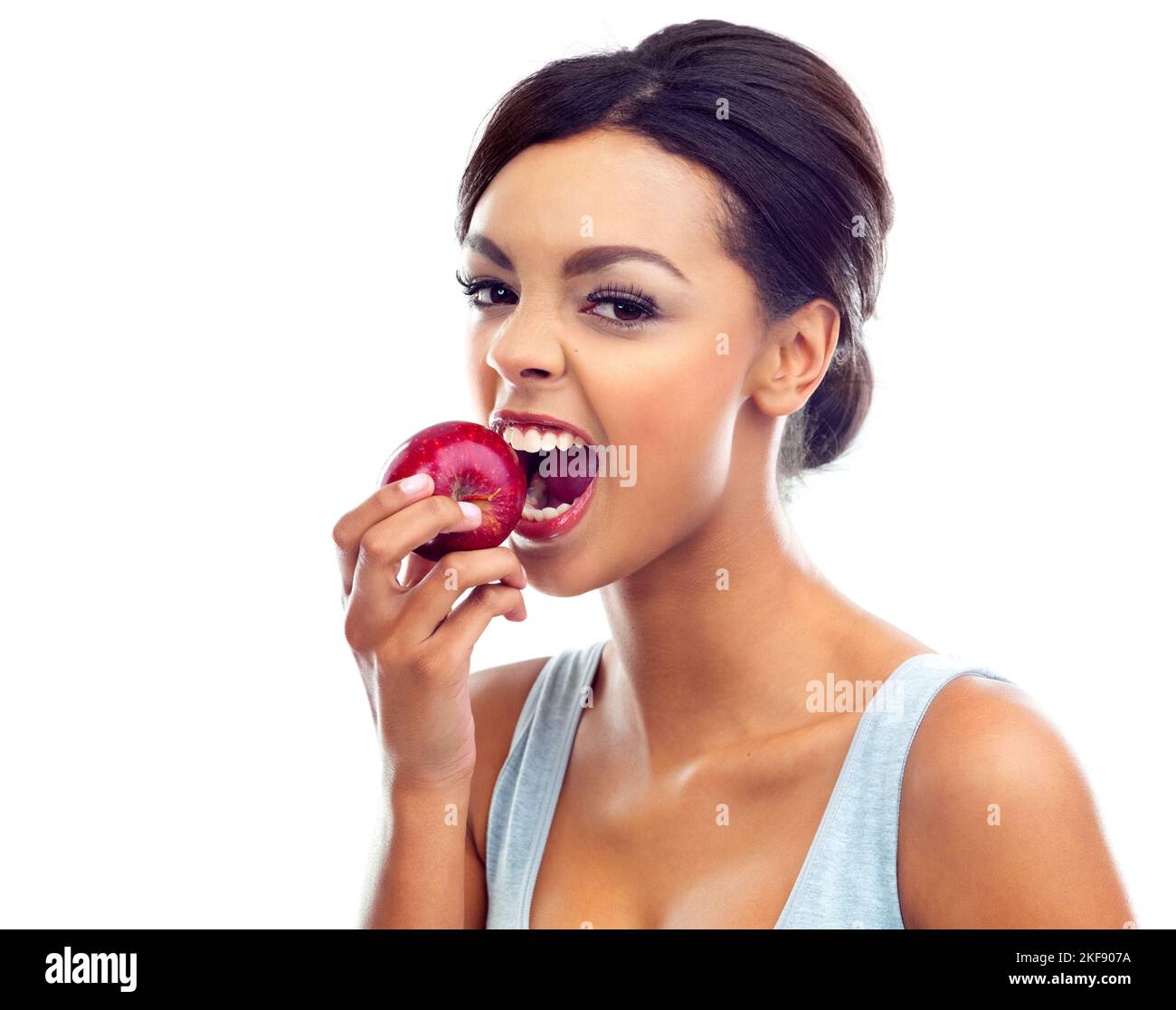 Apples... my favorite. Studio portrait of a young woman biting into an apple Stock Photo - Alamy