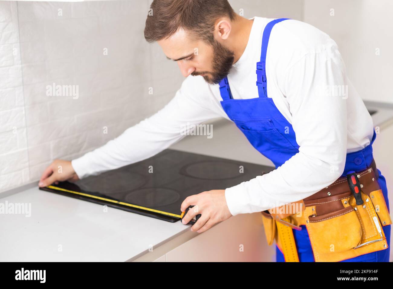 craftsman installs hob in kitchen. Household Appliance Installation ...