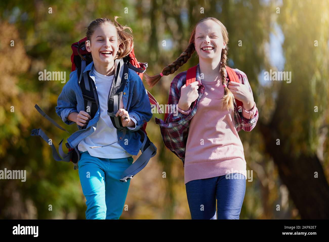 Enjoying the great outdoors together. two young girls wearing backpacks ...