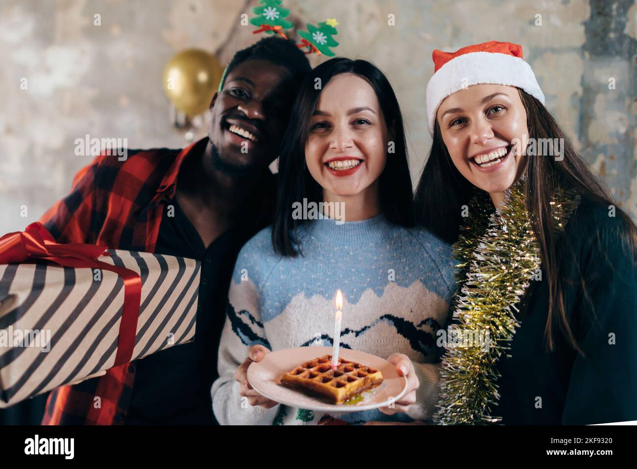 Woman holding birthday cake preparing to blow candle, friends around ...