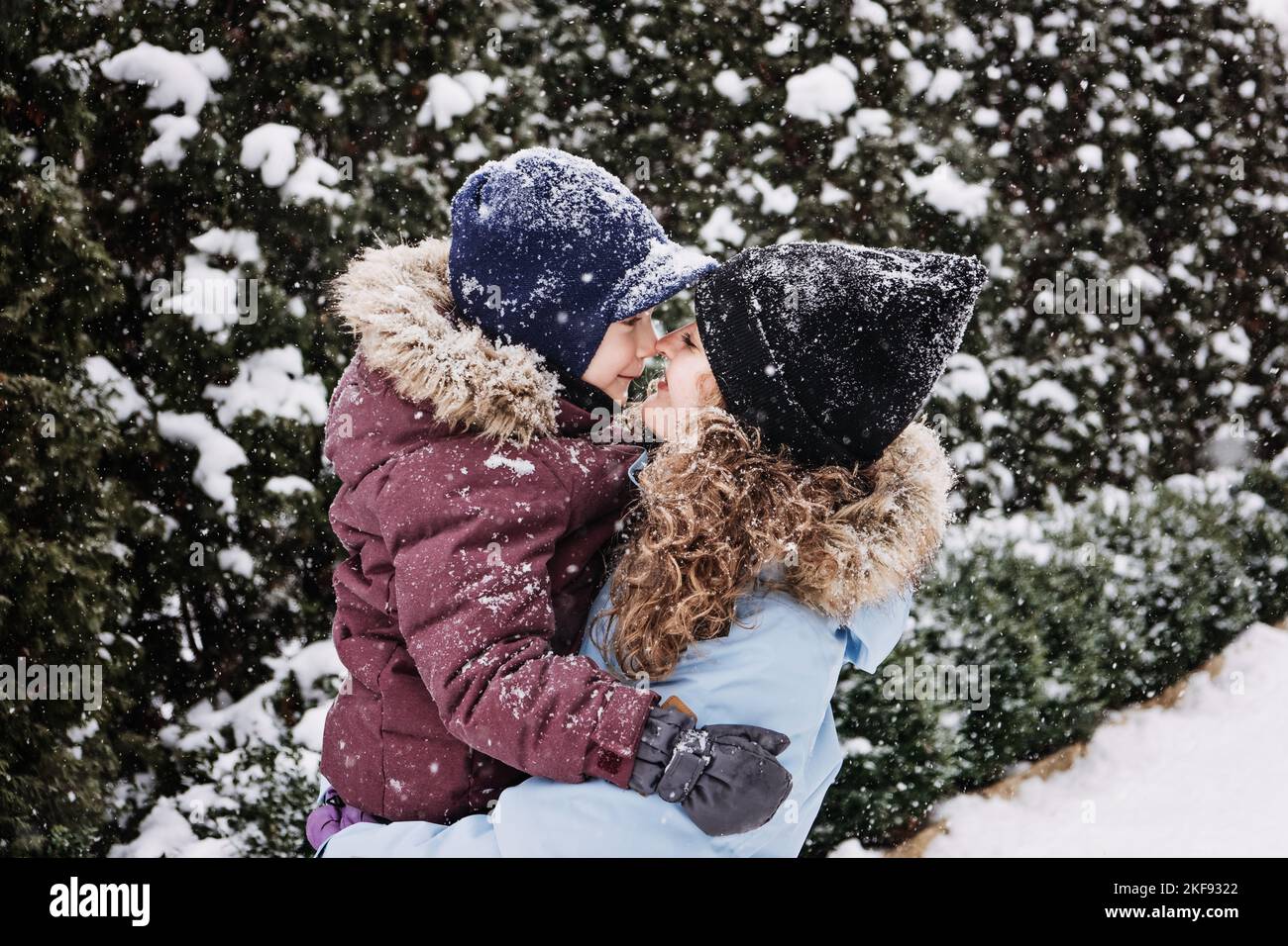Portrait of happy family mother and son in snowy winter park. Outdoors ...