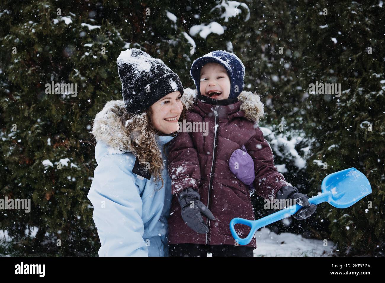 Happy Family, mother and son having fun outdoors in winter snowy nature ...