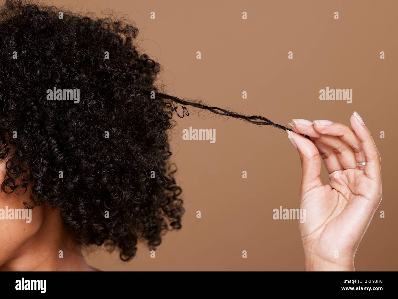 Hair care, beauty and black woman hand with curly hair on brown ...