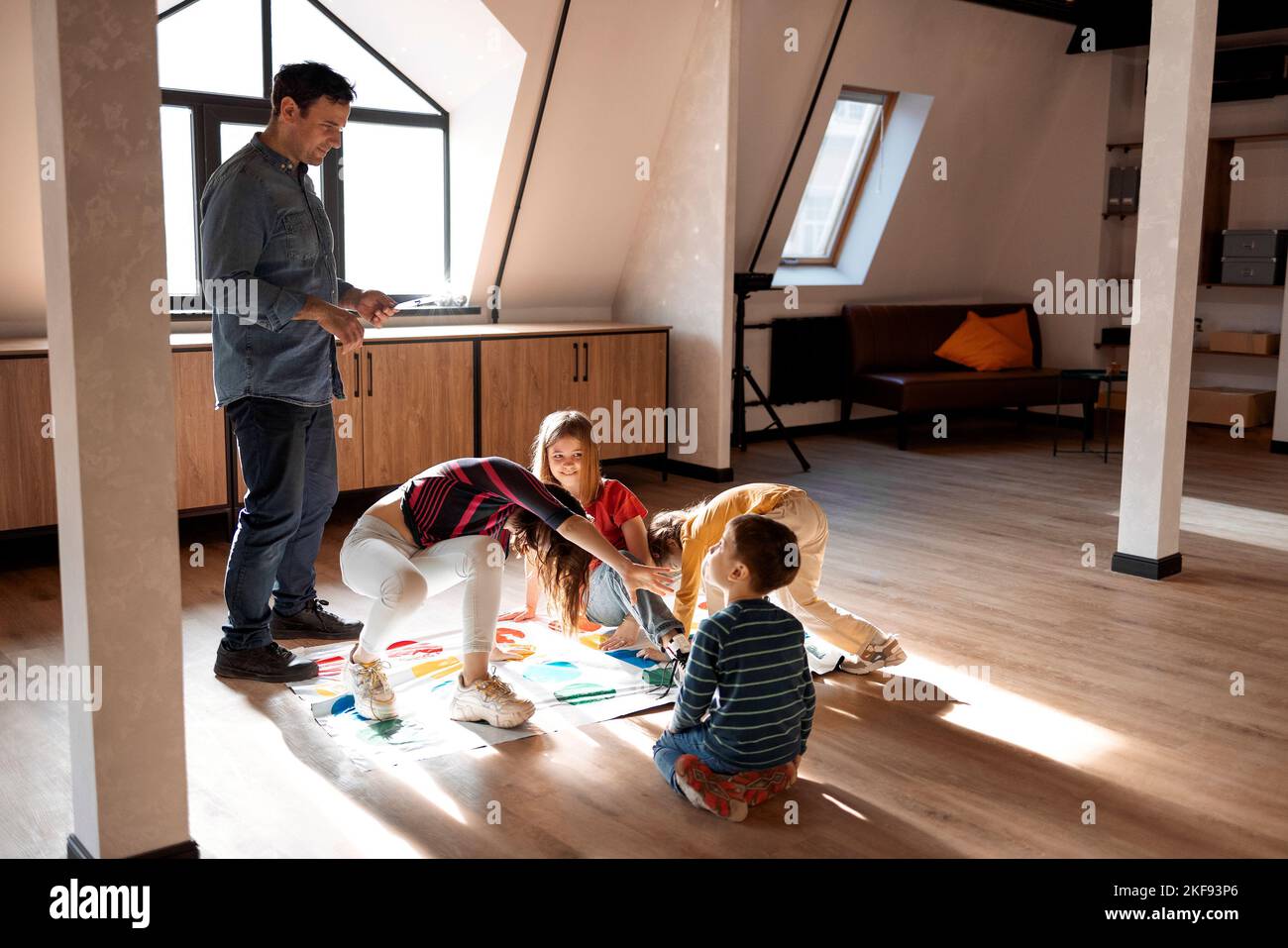 Happy big family having fun together, kids with father playing twister ...