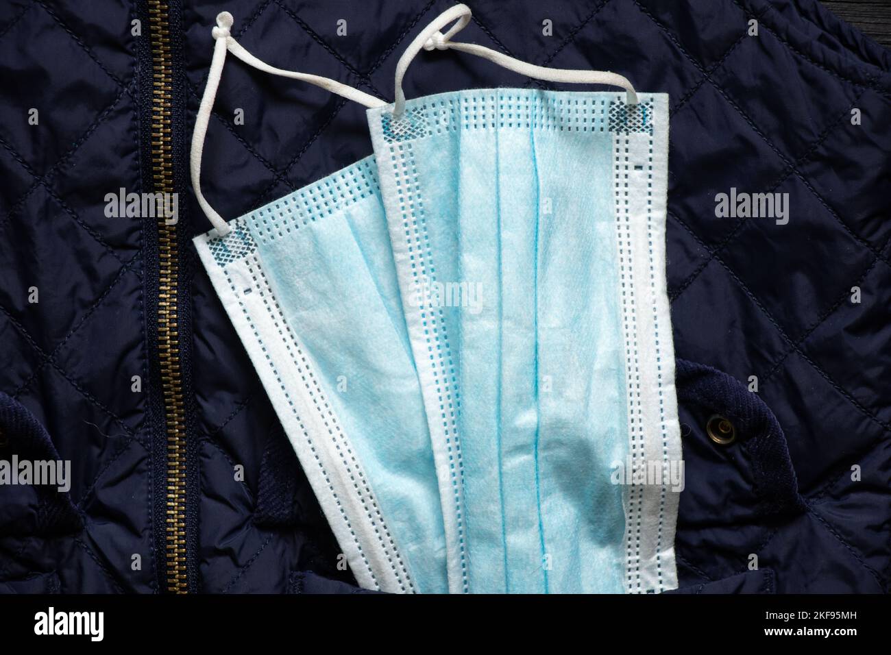 disposable medical blue mask lies in the pocket of the winter jacket ...