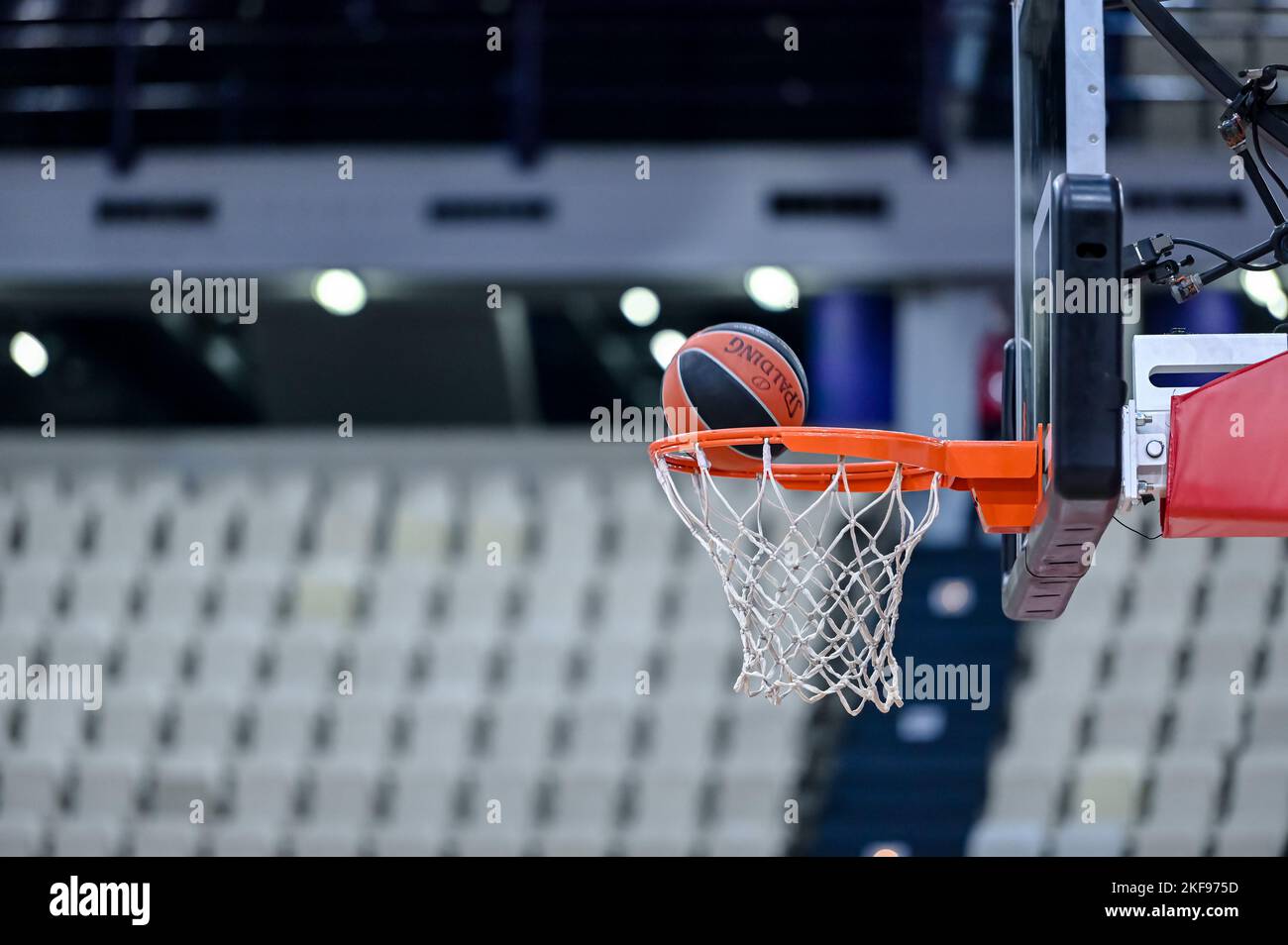 Basket ball entering the net in a basketball court with empty seats ...
