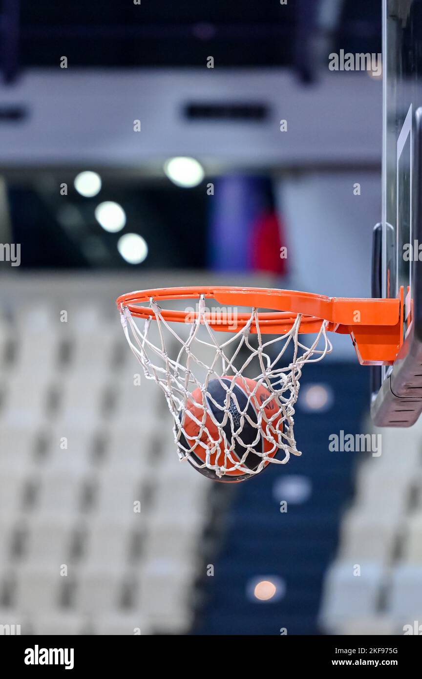 Basket ball entering the net in a basketball court with empty seats ...