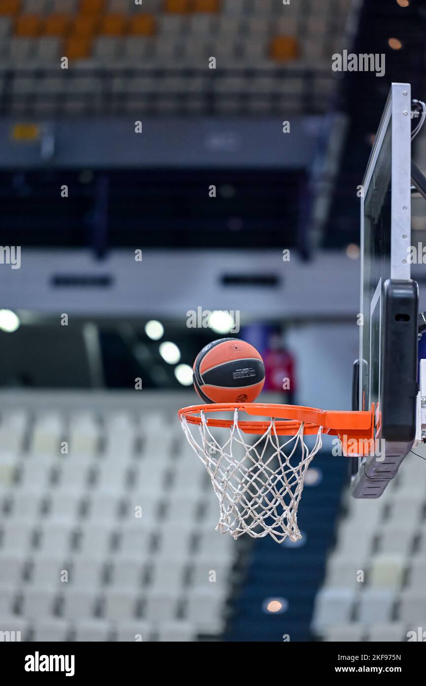 Basket ball entering the net in a basketball court with empty seats ...