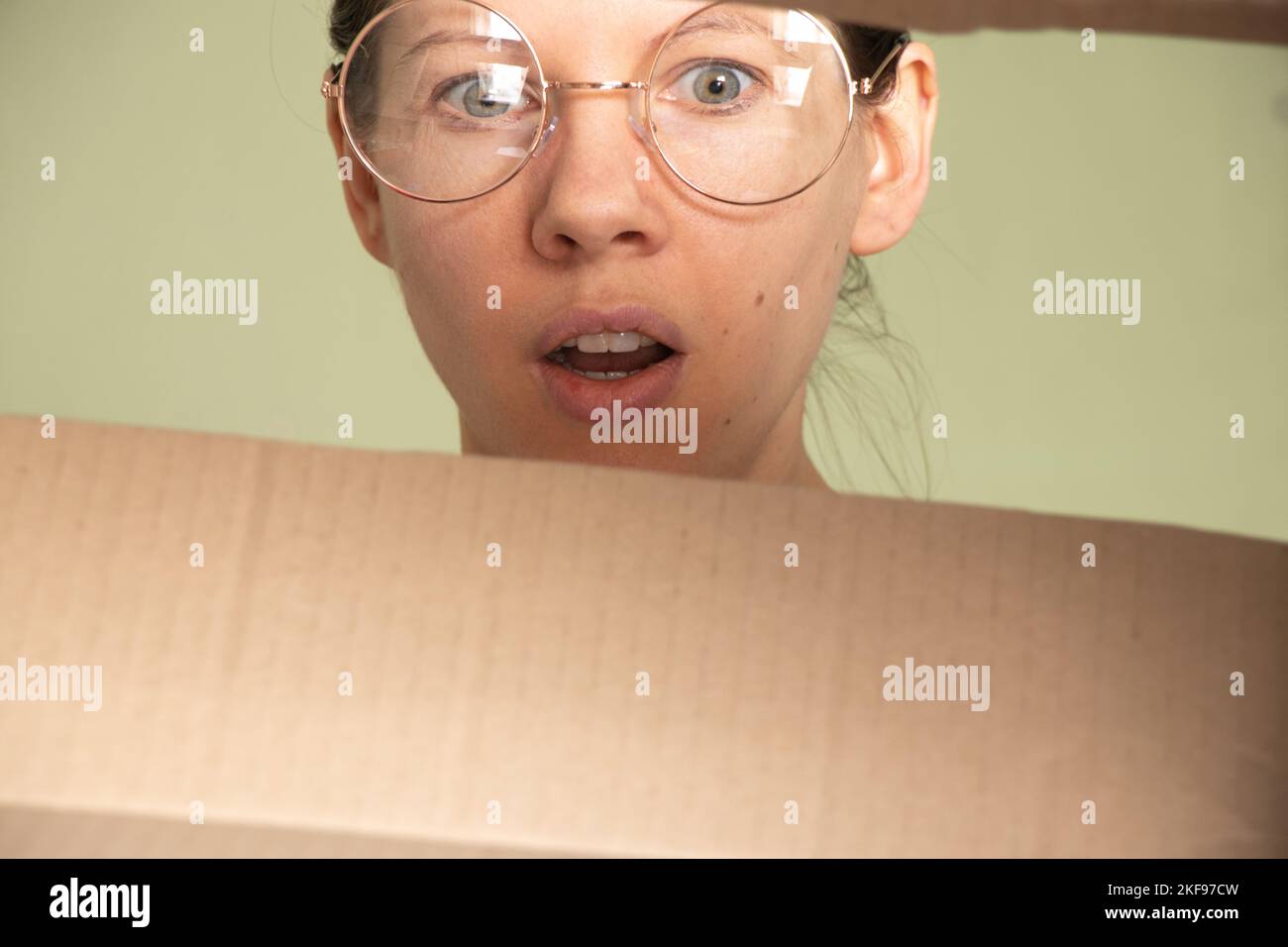 the girl's face looks into the cardboard box, receiving the parcel ...