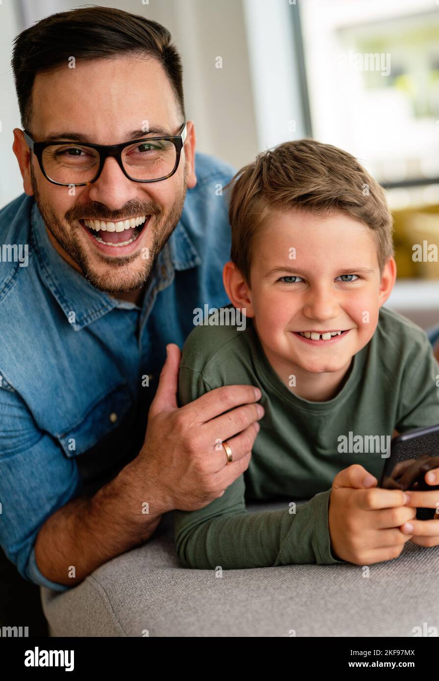 Joyful father and son having fun, spending tim at home together. Single ...