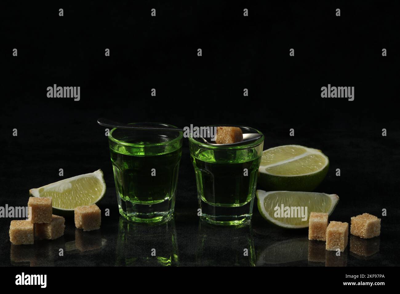 green absinthe drink on the black background with sugar and lime Stock ...