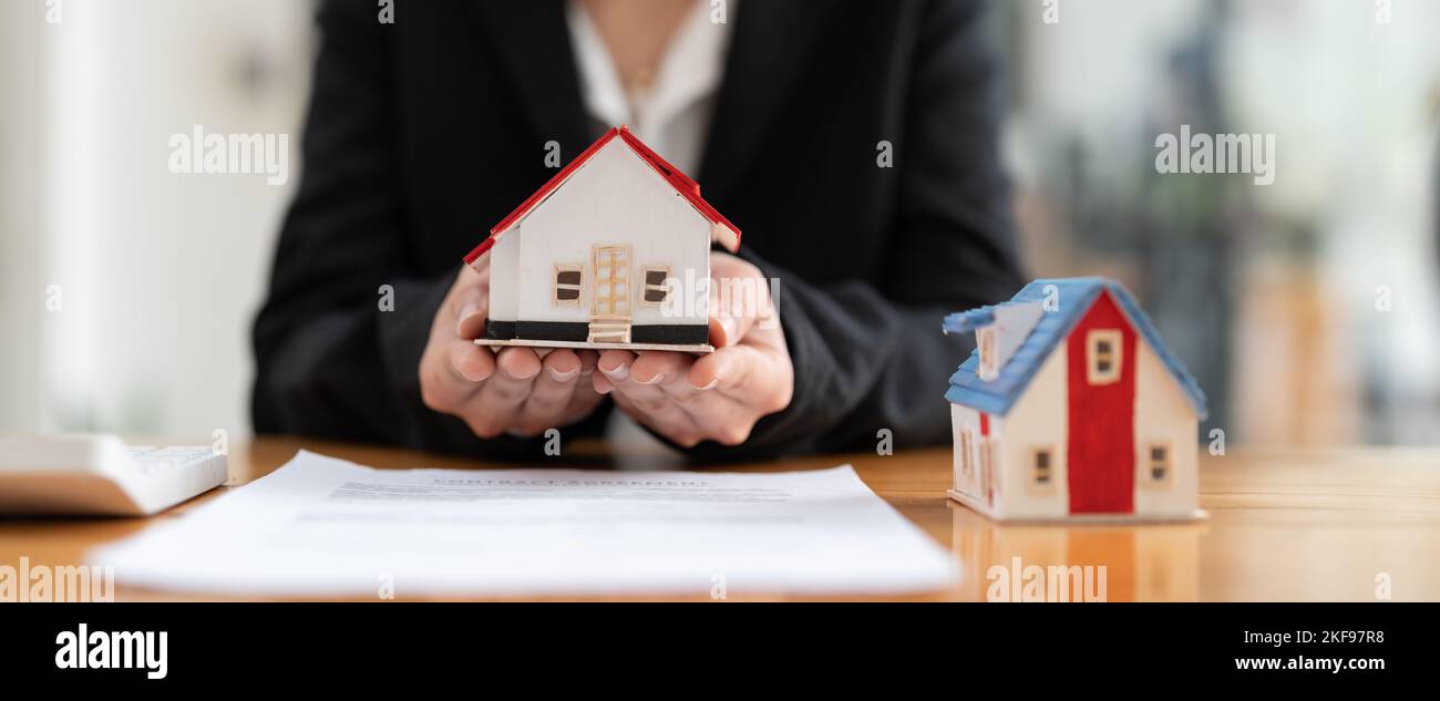 House model with real estate agent and customer discussing for contract ...