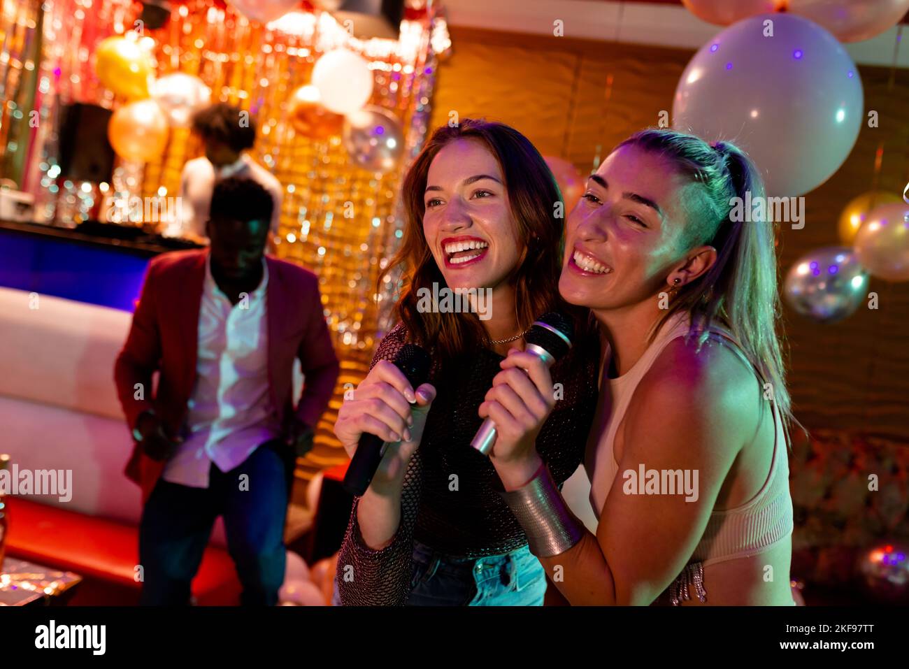 Two Happy Caucasian Female Friends Singing Karaoke At A Nightclub Bar