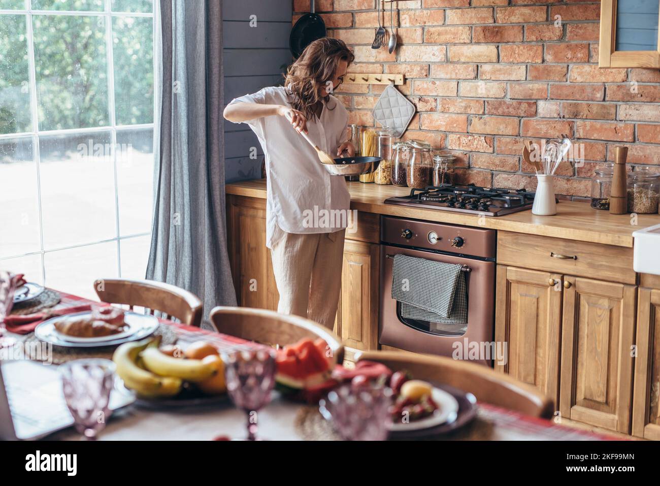 Young woman cooks food in a skillet Stock Photo - Alamy