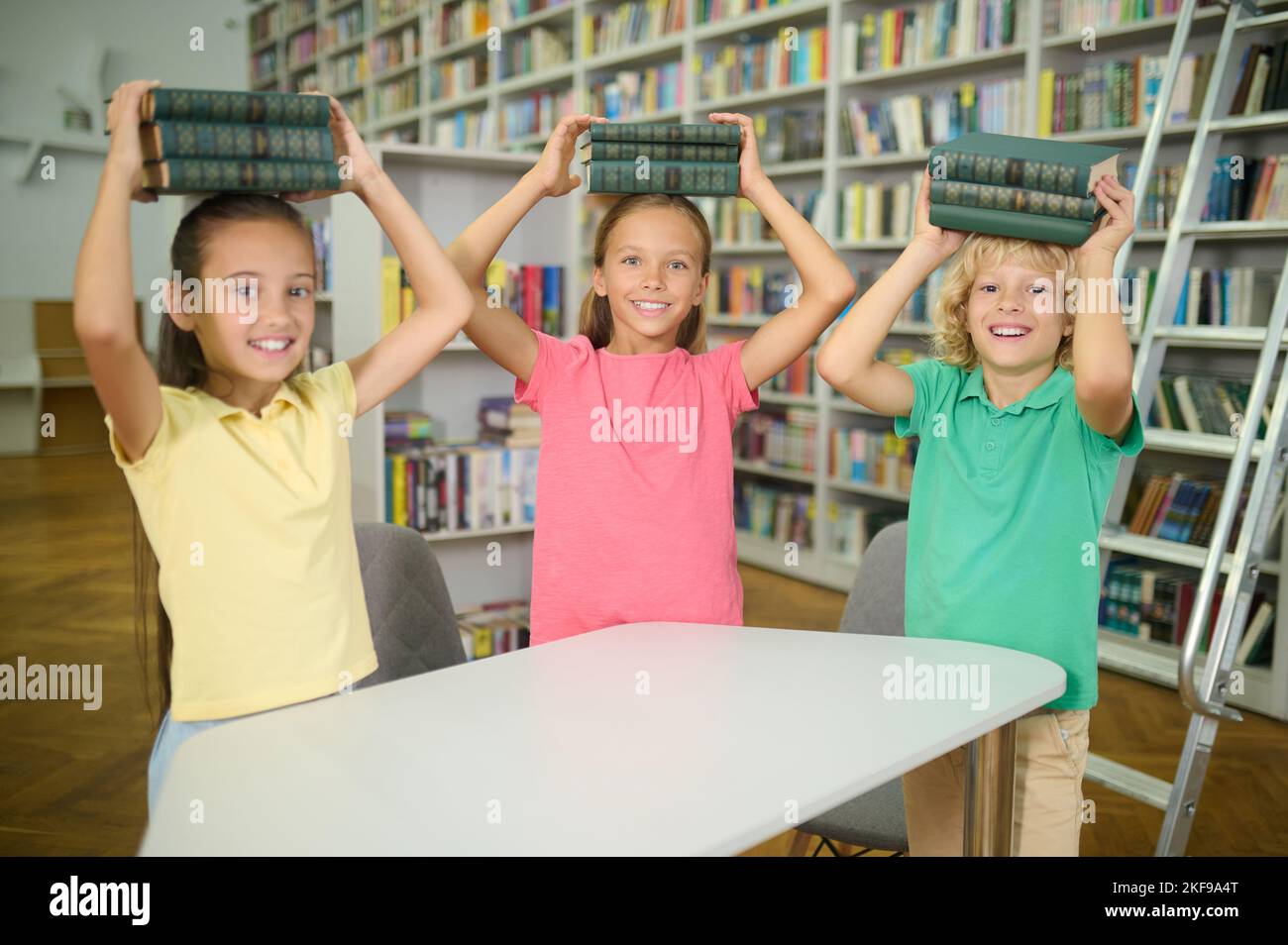 Happy classmates spending time in the school library Stock Photo - Alamy