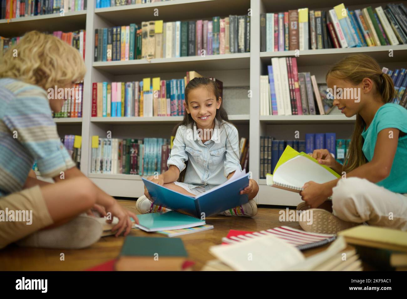 Group of schoolkids having a lesson of literature in the library Stock ...