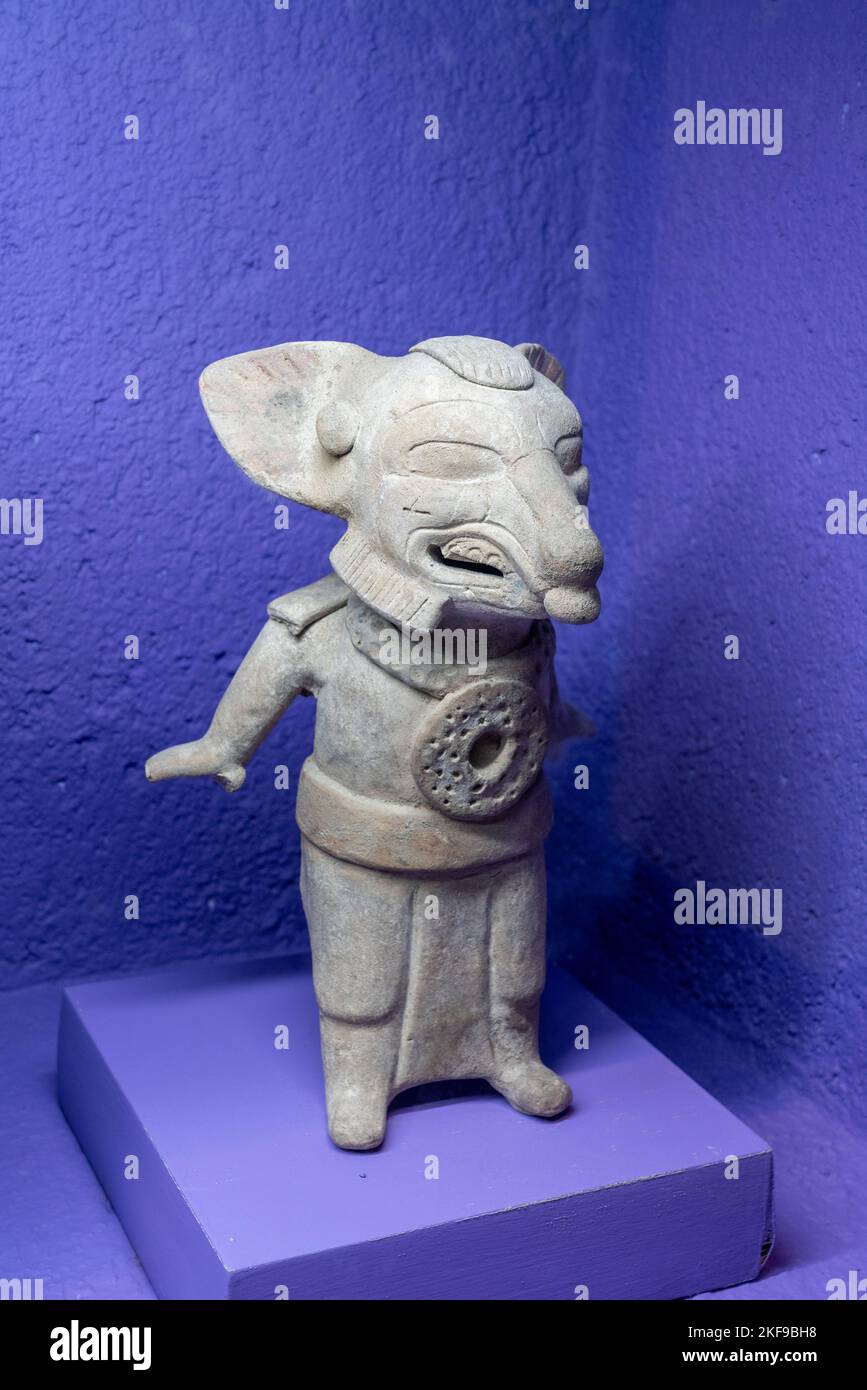 A ceramic figure of a priest in ceremonial dress, wearing a badger mask ...