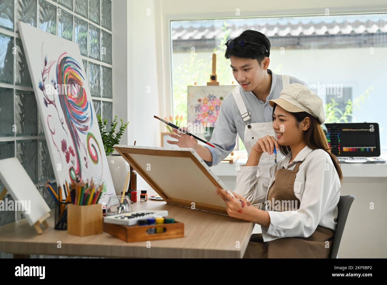 Shot of art students creating their artwork, working together in bright ...