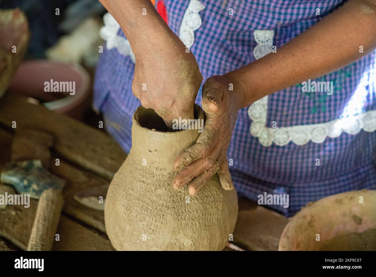 Making red clay pottery. The potter shapes red clay by hand to make a ...