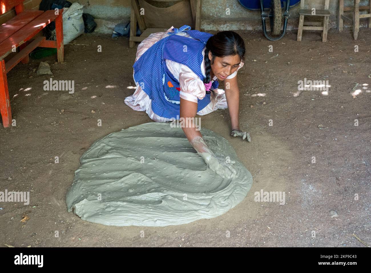 Making red clay pottery. Potter spreads mixed clay on a sand base to ...