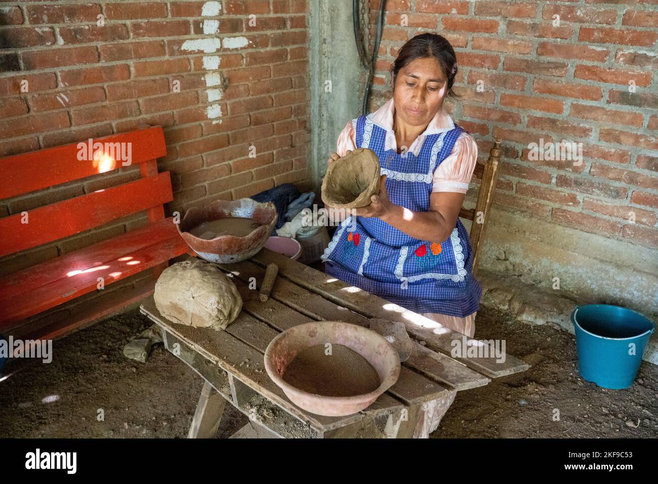 Making red clay pottery. The potter begins to shape red clay by hand to ...