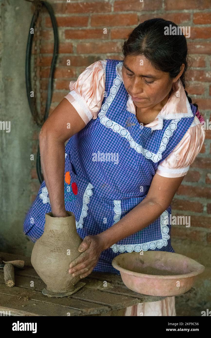 Making red clay pottery. The potter shapes red clay by hand to make a ...