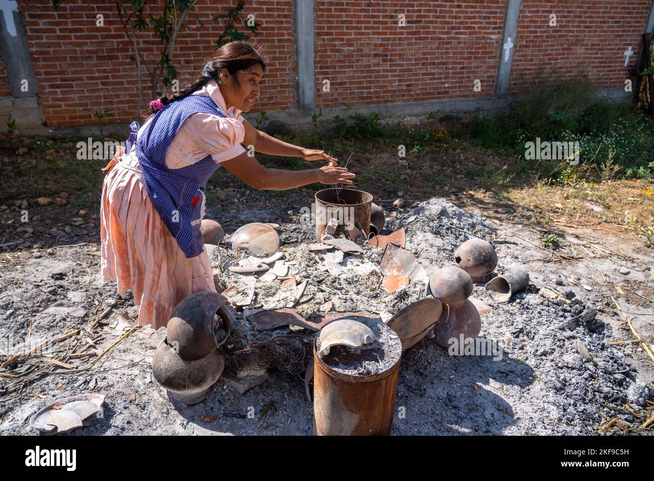 Making red clay pottery. The potter starts to prepare to build a fire ...