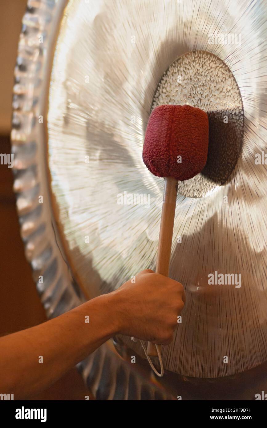 Man Playing Suspended Gong During Spiritual Practice Stock Photo - Alamy