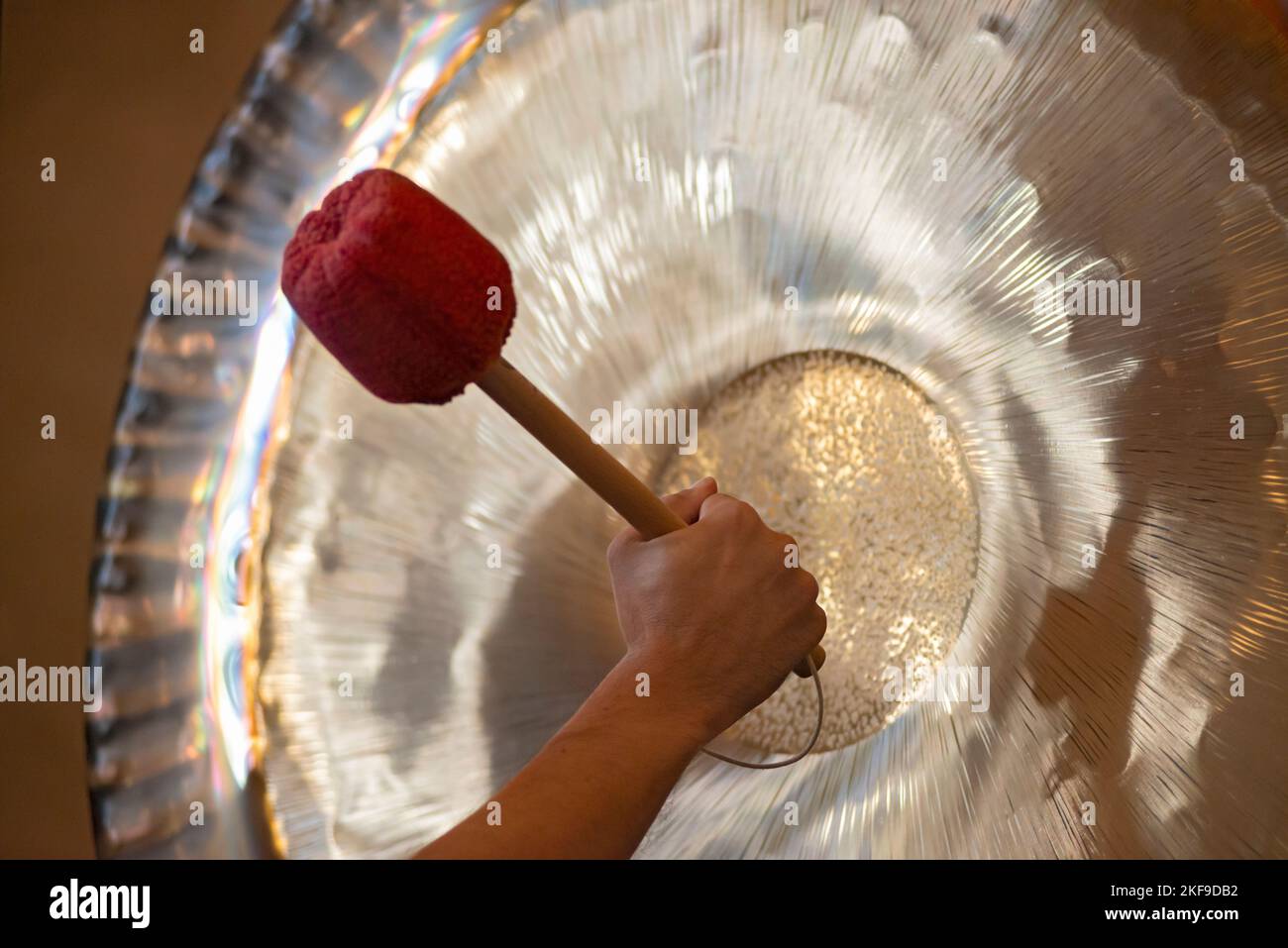 Man Playing Suspended Gong During Spiritual Practice Stock Photo - Alamy