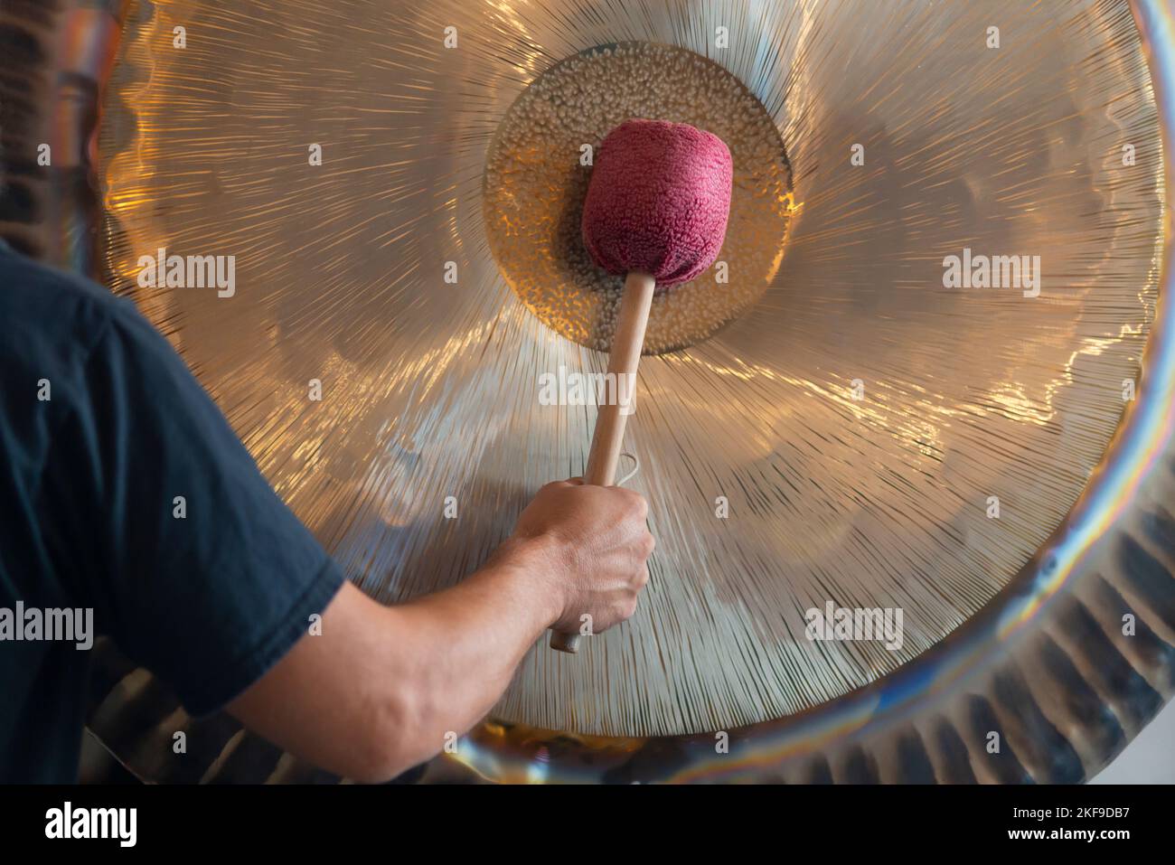 Man Playing Suspended Gong During Spiritual Practice Stock Photo - Alamy