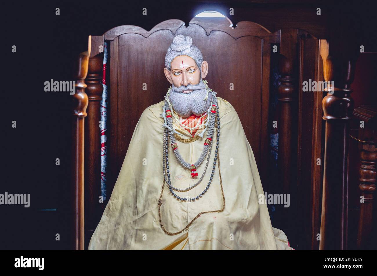 A statue of Lokenath Brahmachari sitting on a wooden chair Stock Photo ...