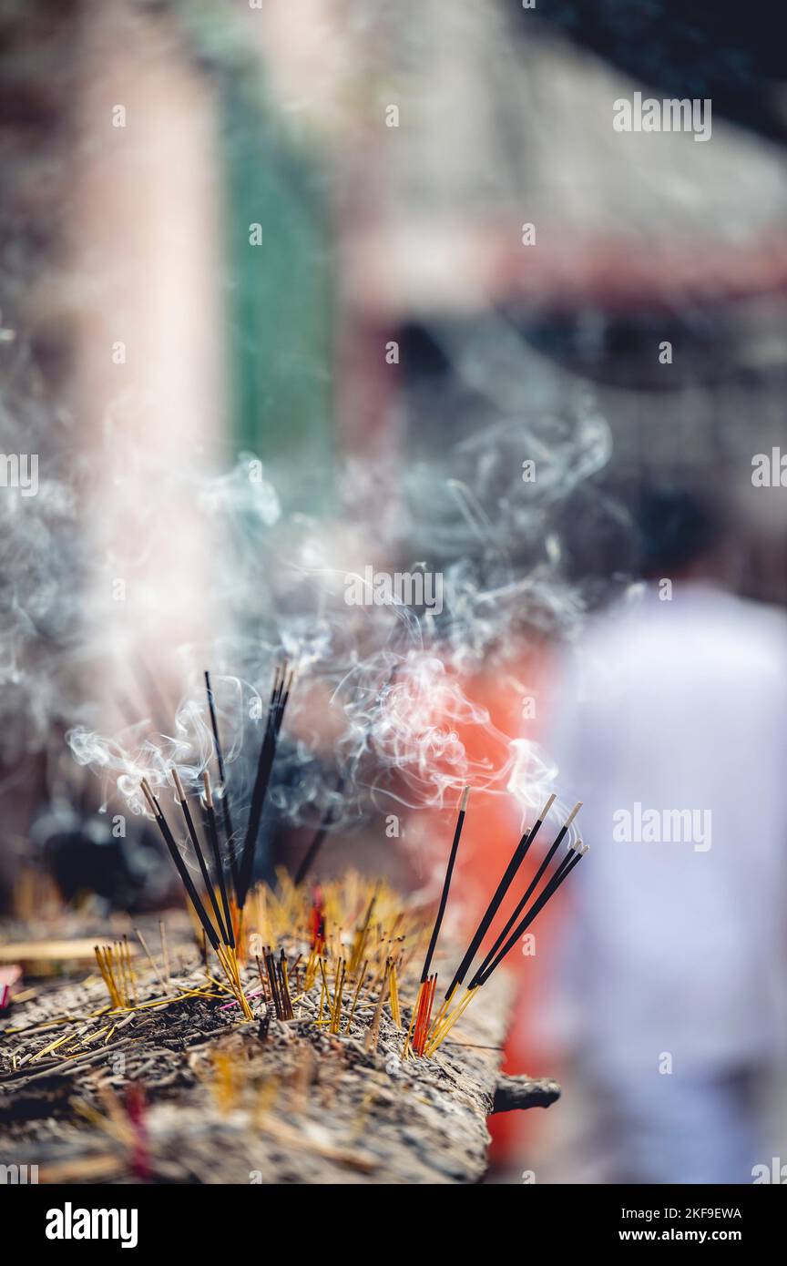 A vertical shot of burning aromatic incense sticks to show respect to ...