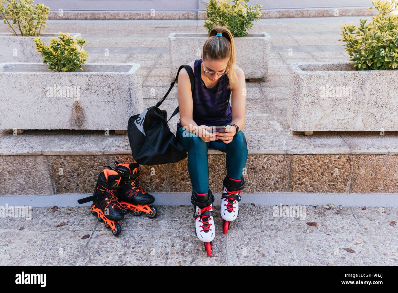 young blonde girl getting ready to go out on inline skates by looking ...